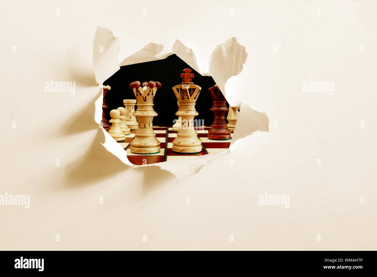 chess pieces behind hole in blank paper Stock Photo - Alamy