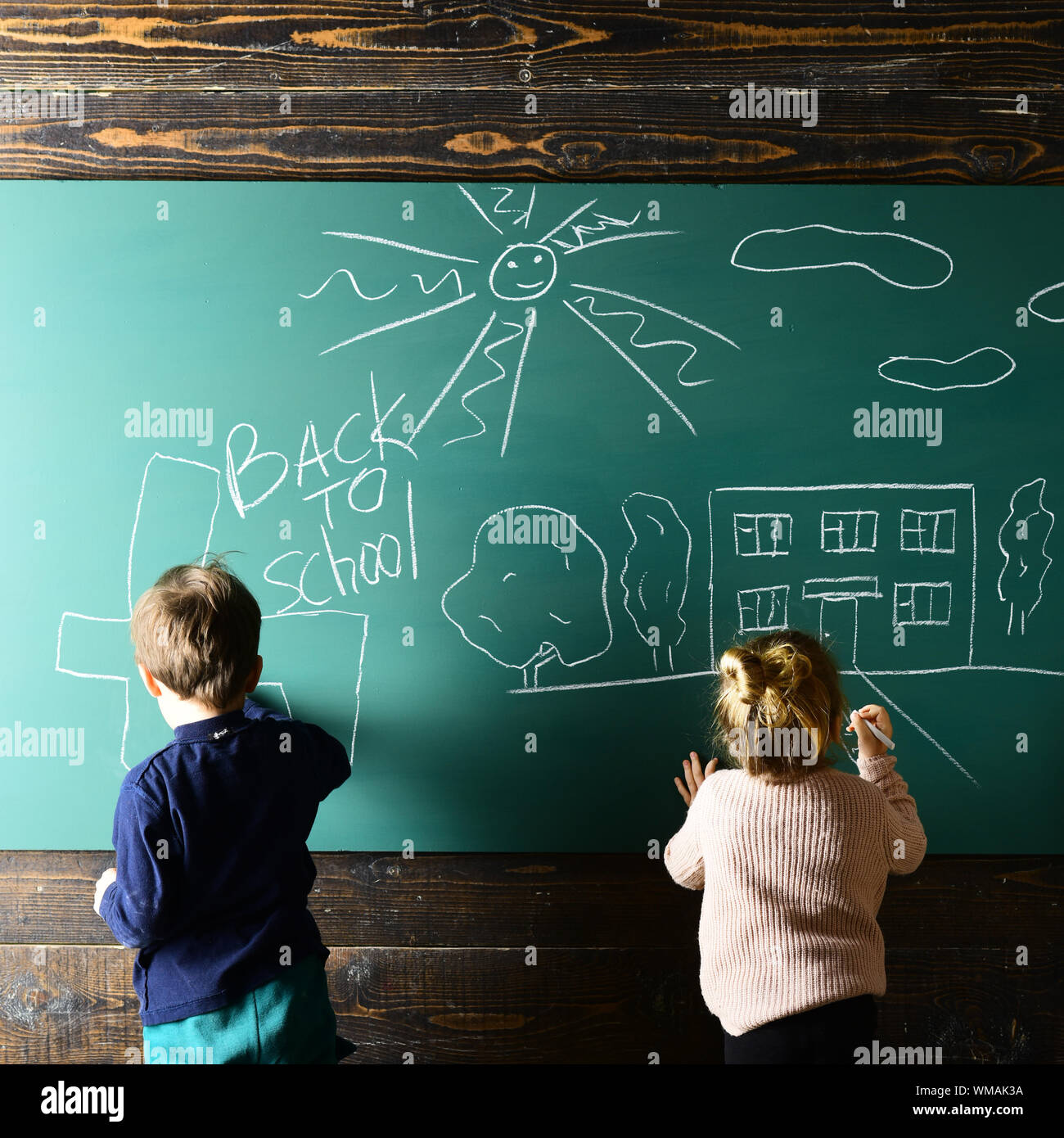 Teacher and elementary age children drawing at classroom in school ...