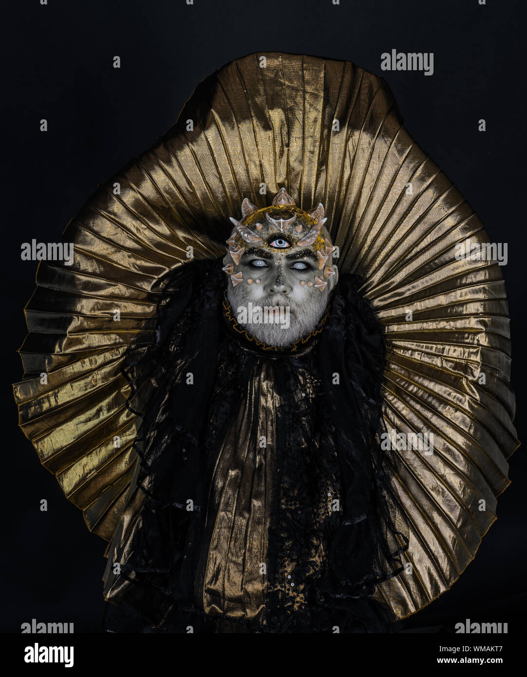 Man with third eye, thorns or warts. Demon with golden collar on black ...