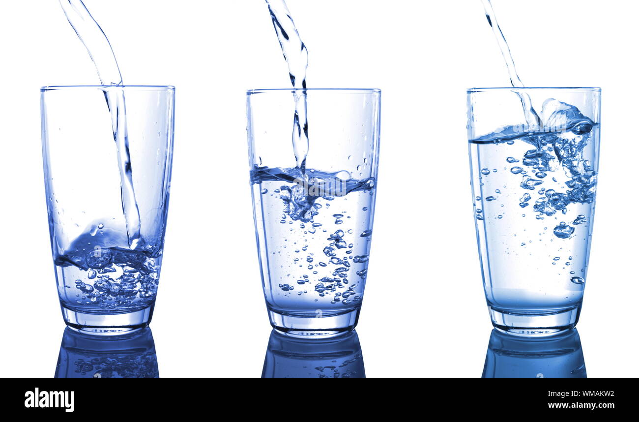 filling a glass of water isolated on white background Stock Photo - Alamy