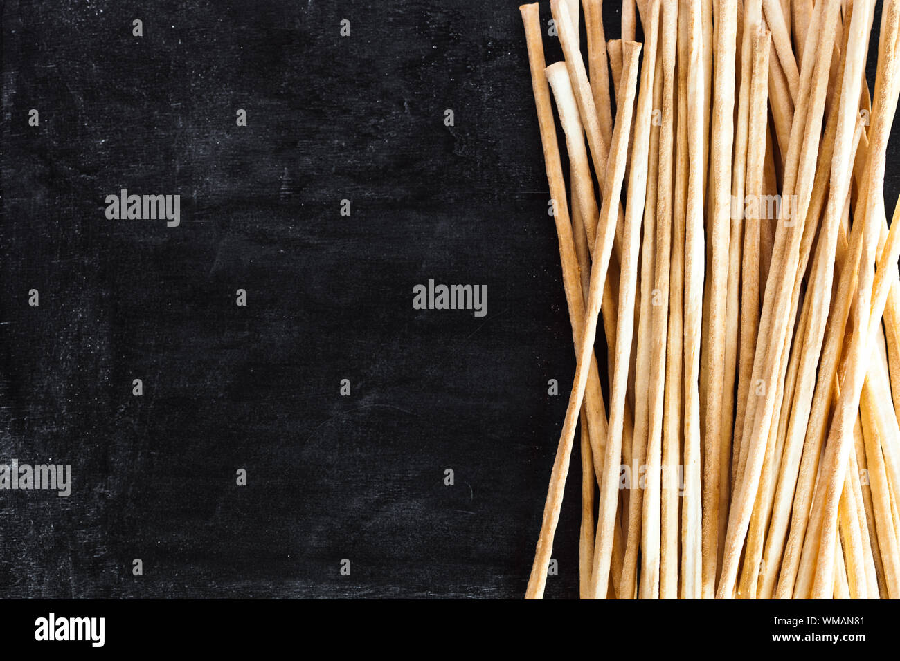 top view of breadsticks grissini torinesi on blackboard background ...