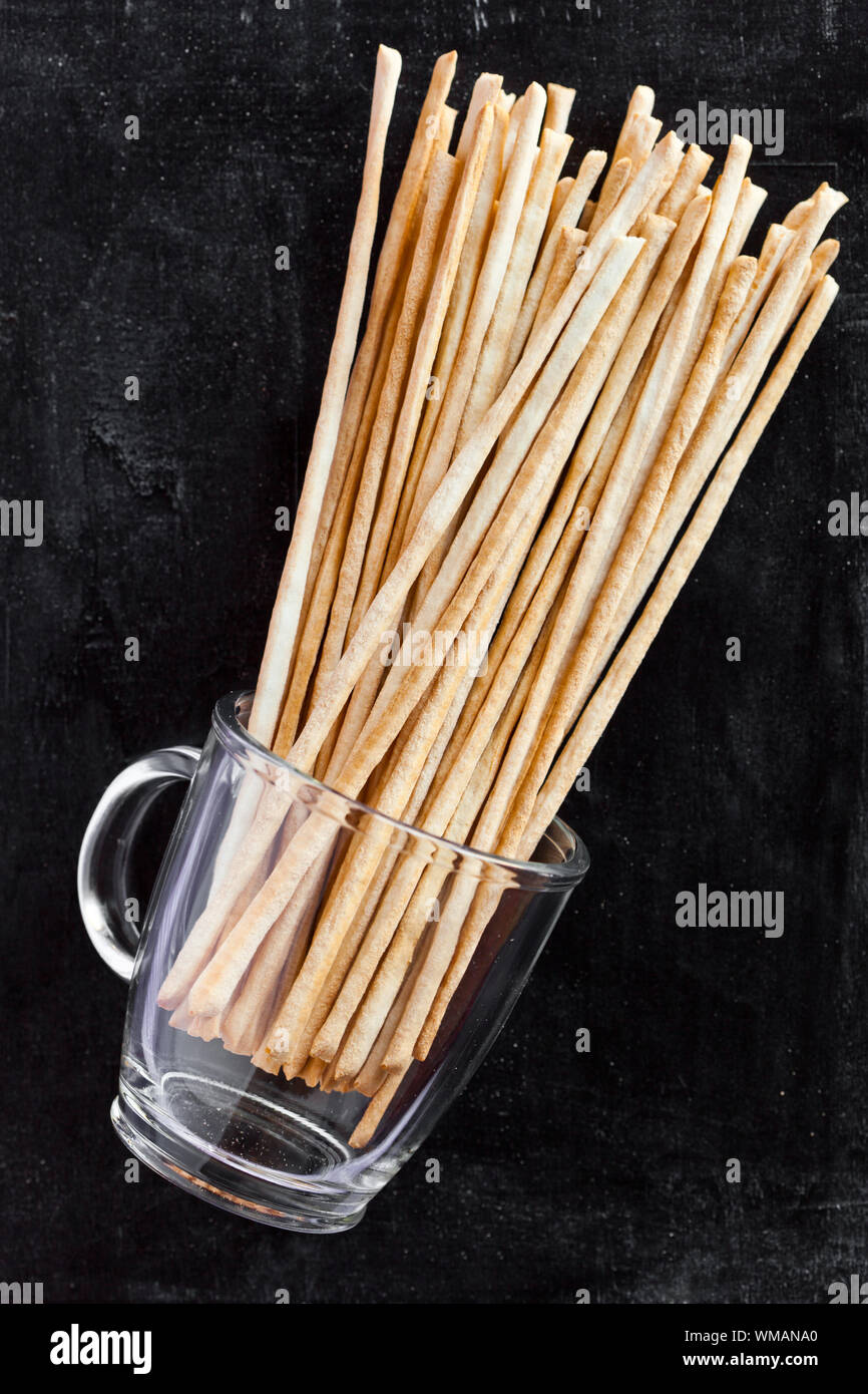 breadsticks grissini torinesi in glass cup on blackboard background ...