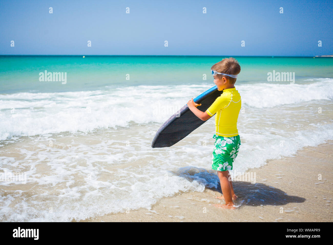 Little boy in yellow has fun surfing Stock Photo - Alamy