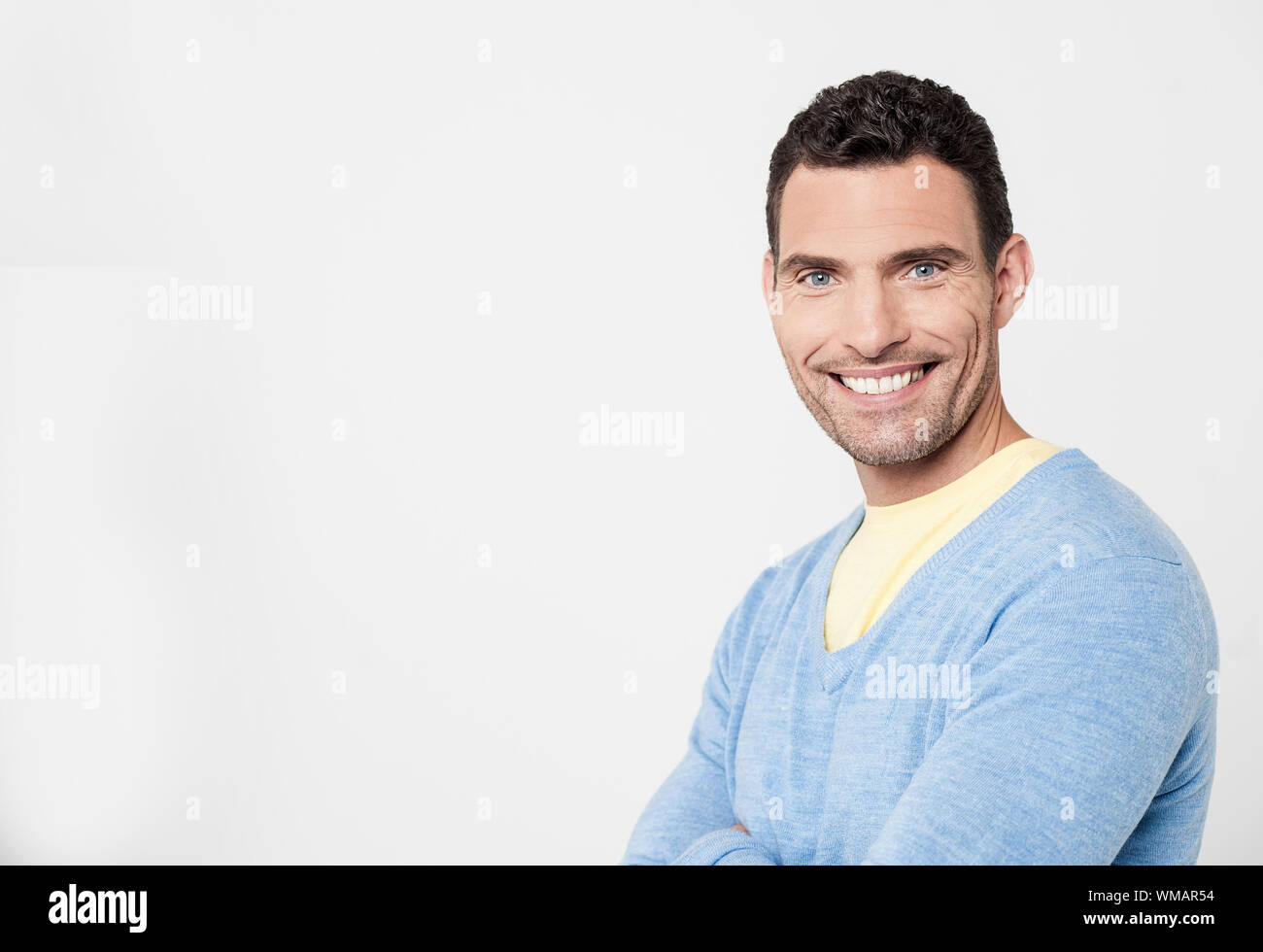 Handsome happy man posing with folded arms Stock Photo - Alamy