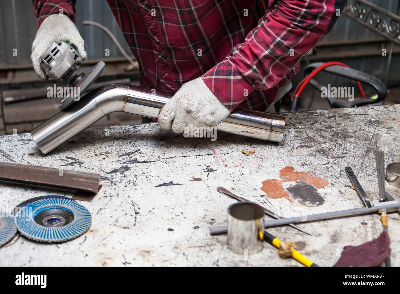 Surface preparation of stainless steel pipes using an angle grinder for ...