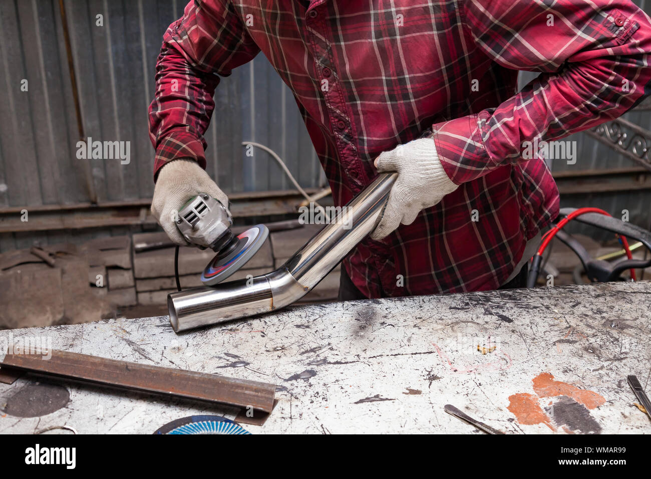 Surface preparation of stainless steel pipes using an angle grinder for ...