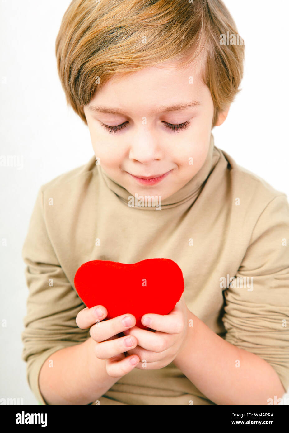 Cute young boy with a red heart in his hands Stock Photo - Alamy