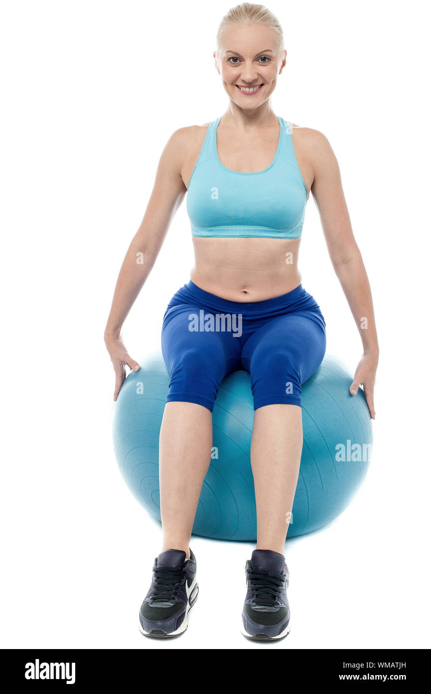Fitness woman sitting on blue fitness ball Stock Photo - Alamy