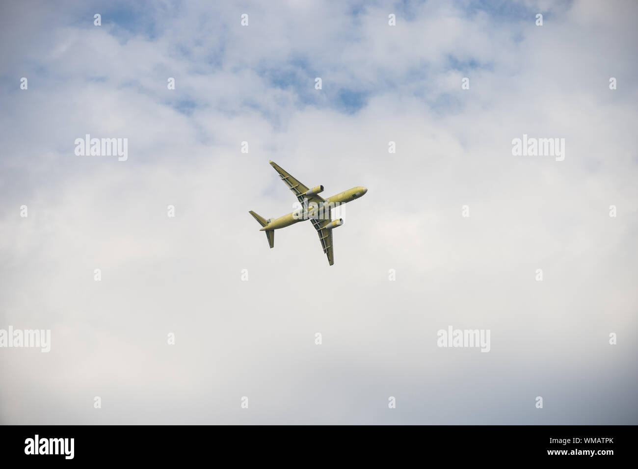 Big yellow passenger plane flying in the cloudy skies. Mid shot Stock ...