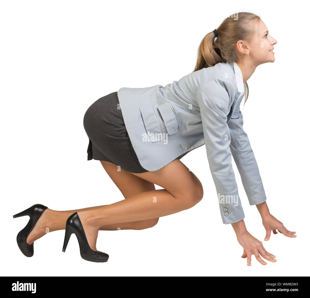 Businesswoman standing in running start pose, smiling, side view ...