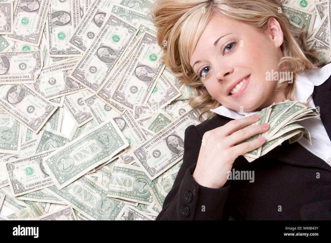 Business woman laying in money Stock Photo - Alamy