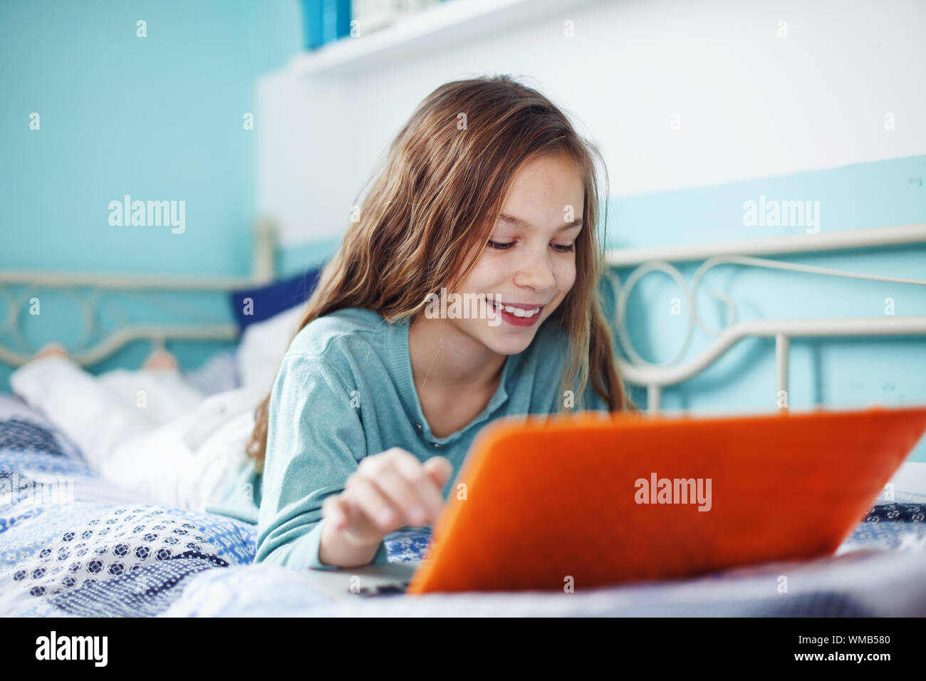 8 years old child having fun using laptop at her bedroom Stock Photo ...
