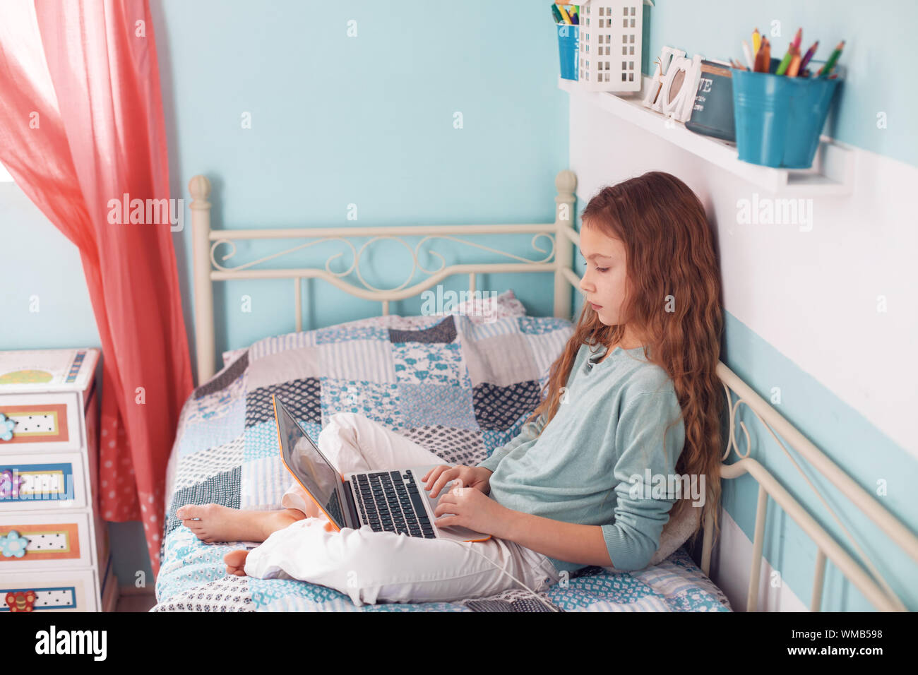 8 years old child having fun using laptop at her bedroom Stock Photo ...