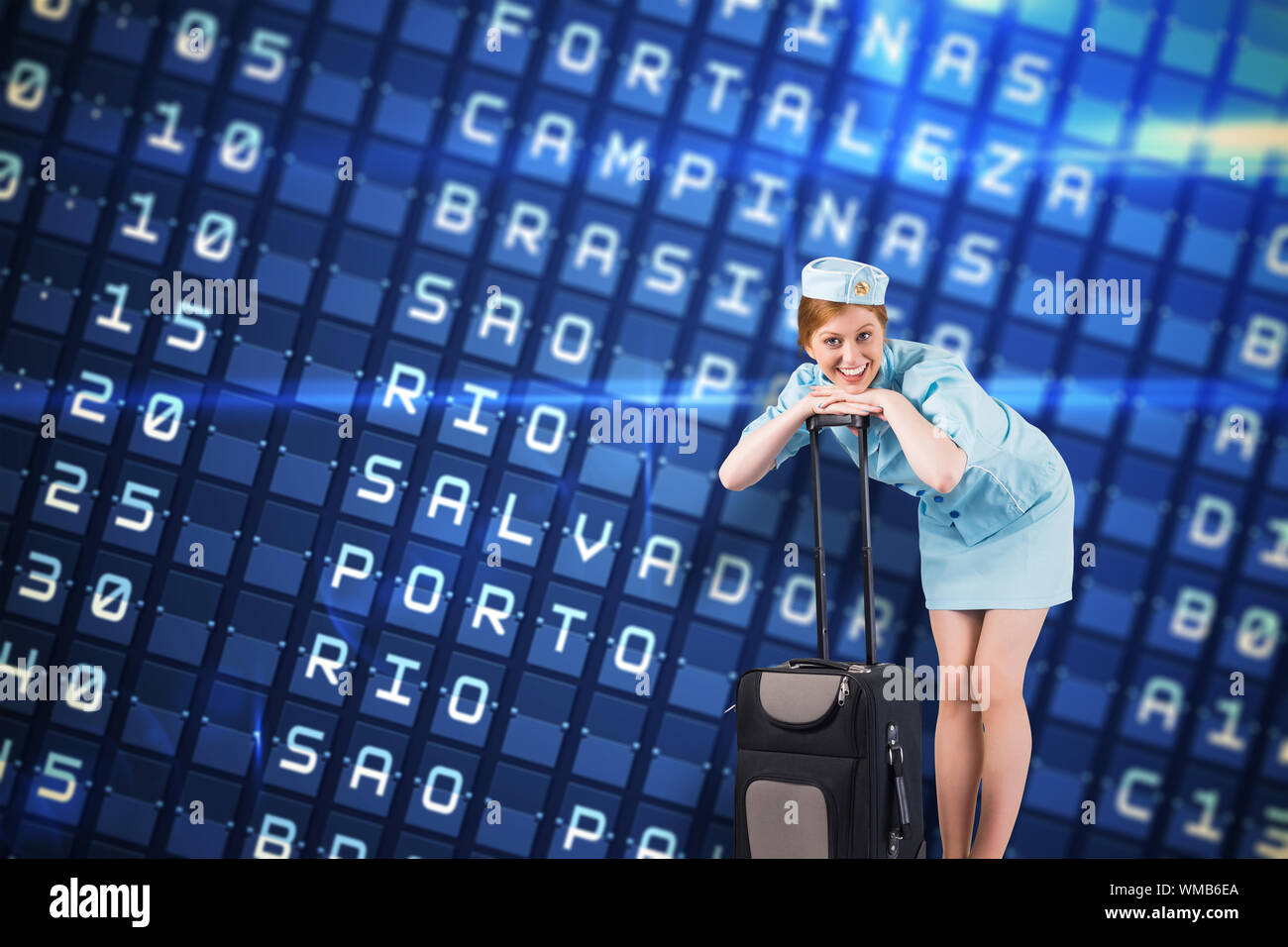 Pretty air hostess smiling at camera against blue departures board for ...