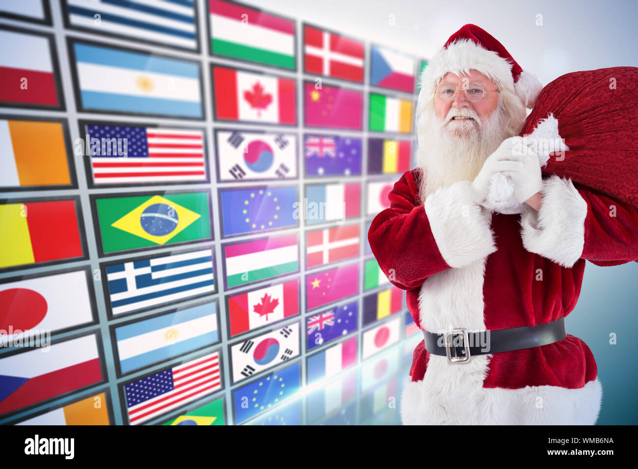 Santa carries his red bag and smiles against screen collage showing ...