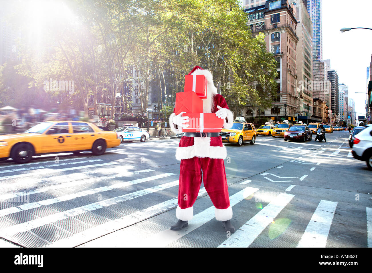 Santa covers his face with presents against new york street Stock Photo ...