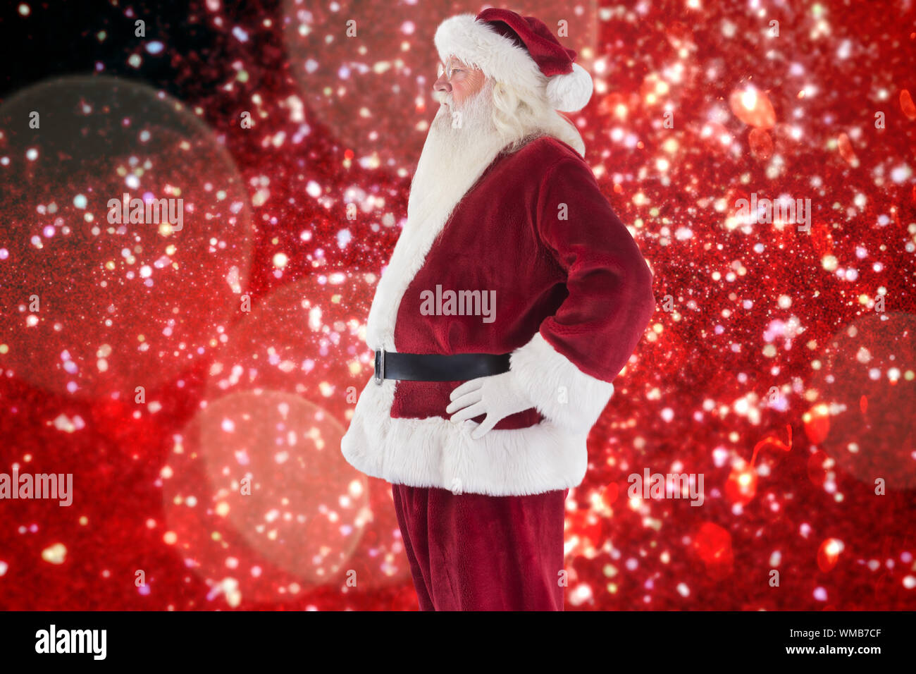Santa Claus shows his side to camera against white snow and stars on ...