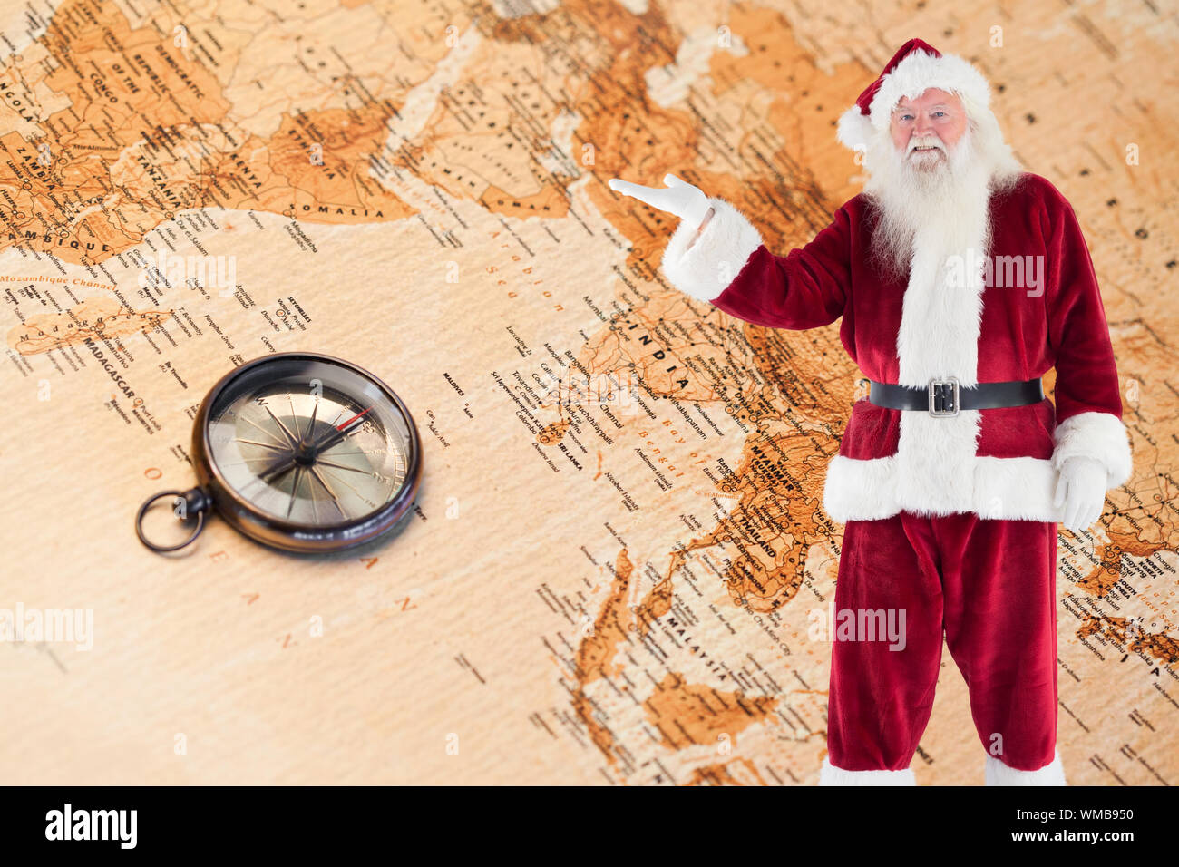 Santa shows something to camera against world map with compass showing ...