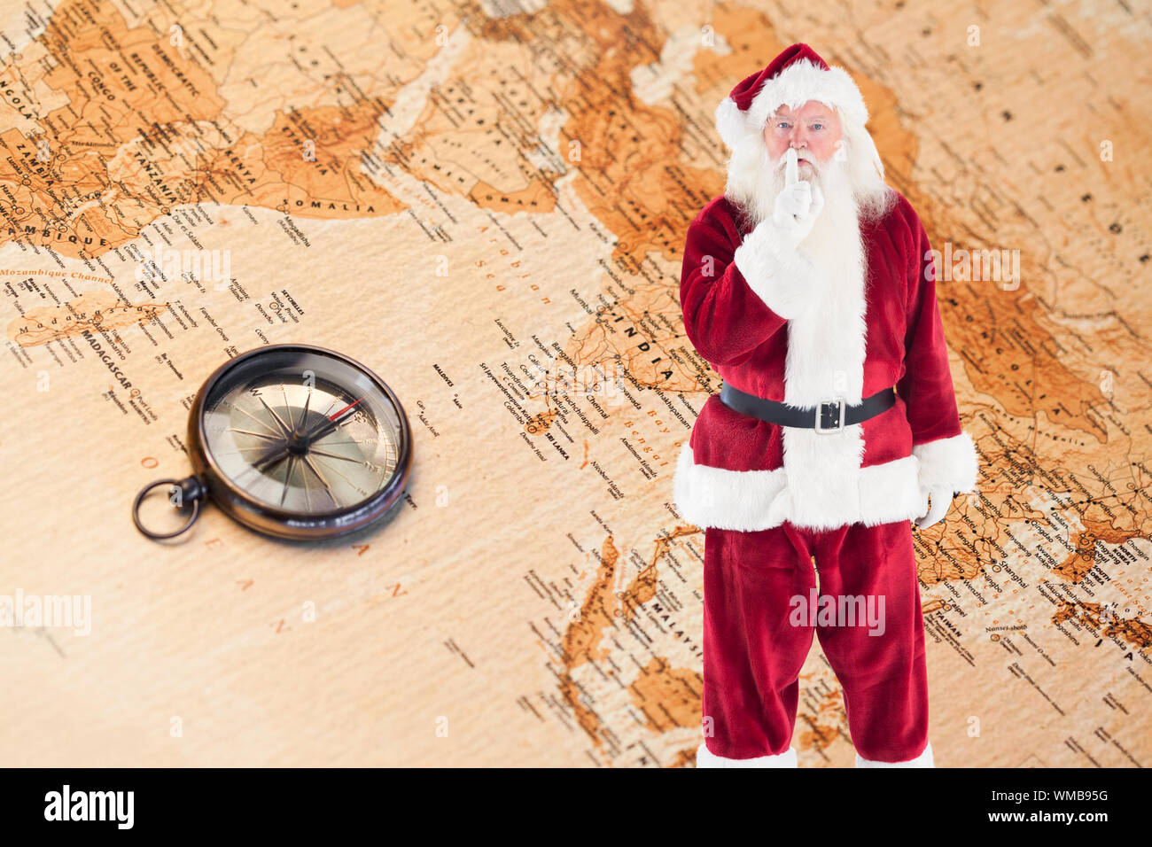Santa asking for quiet to camera against world map with compass showing ...