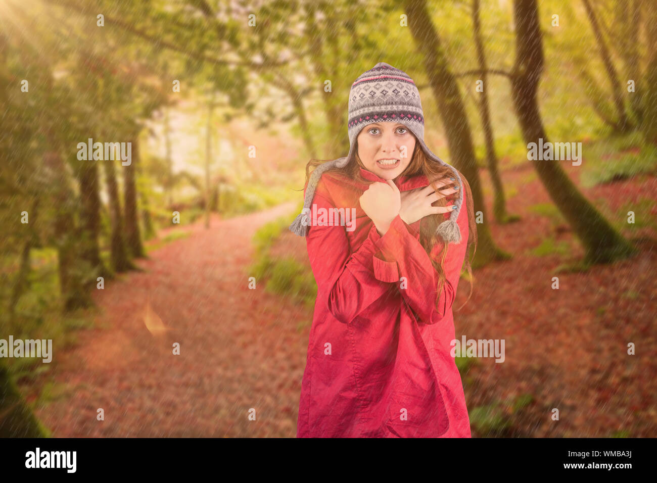 Cold redhead wearing coat and hat against peaceful autumn scene in ...