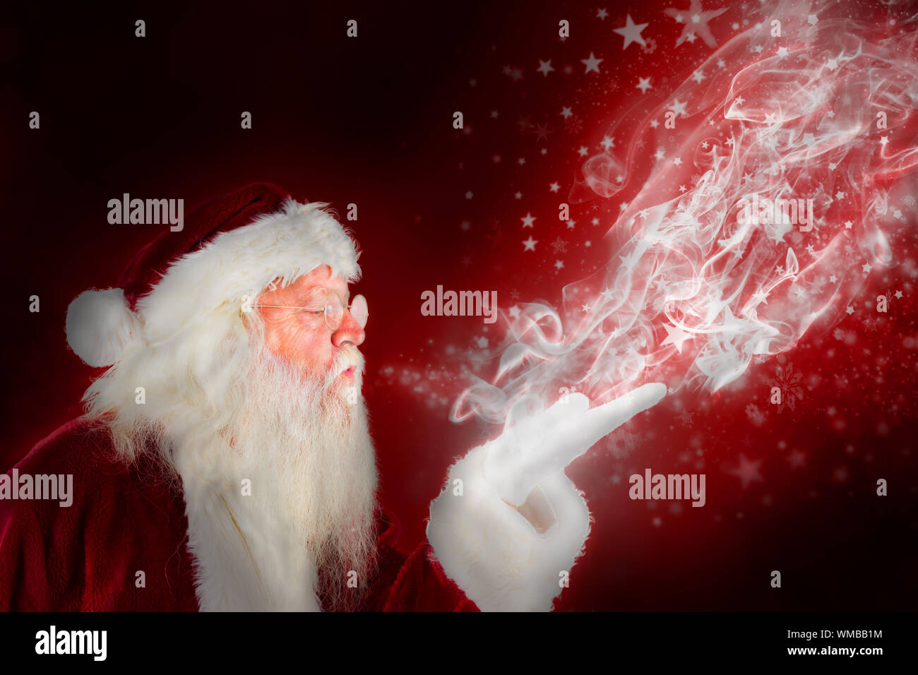 Santa claus blowing against blurred snowflake design Stock Photo - Alamy