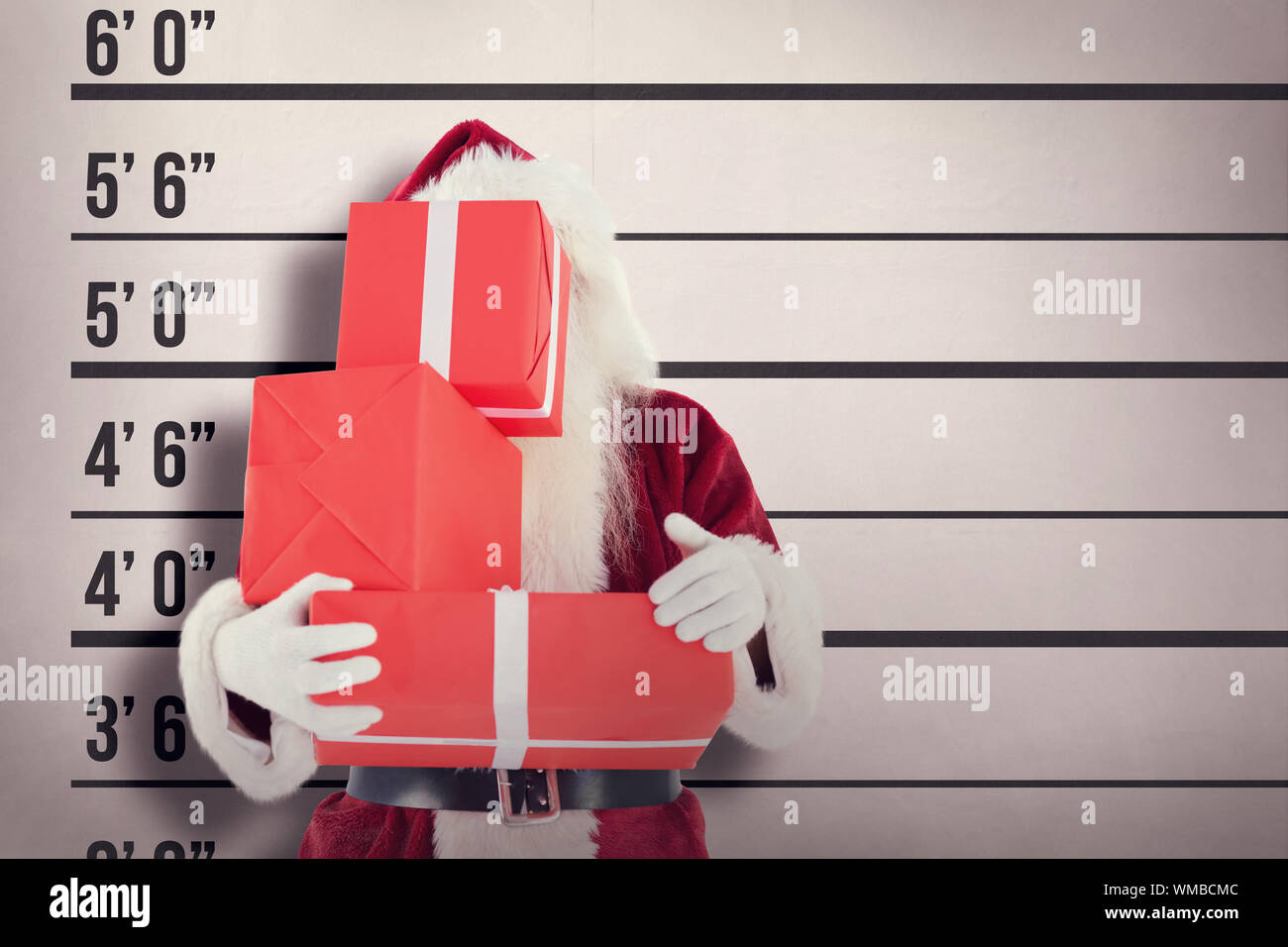 Santa covers his face with presents against mug shot background Stock ...