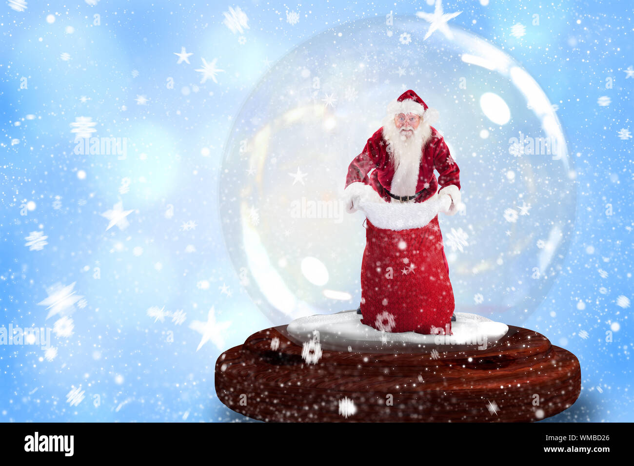 Santa holding open sack snow globe against blue abstract light spot ...