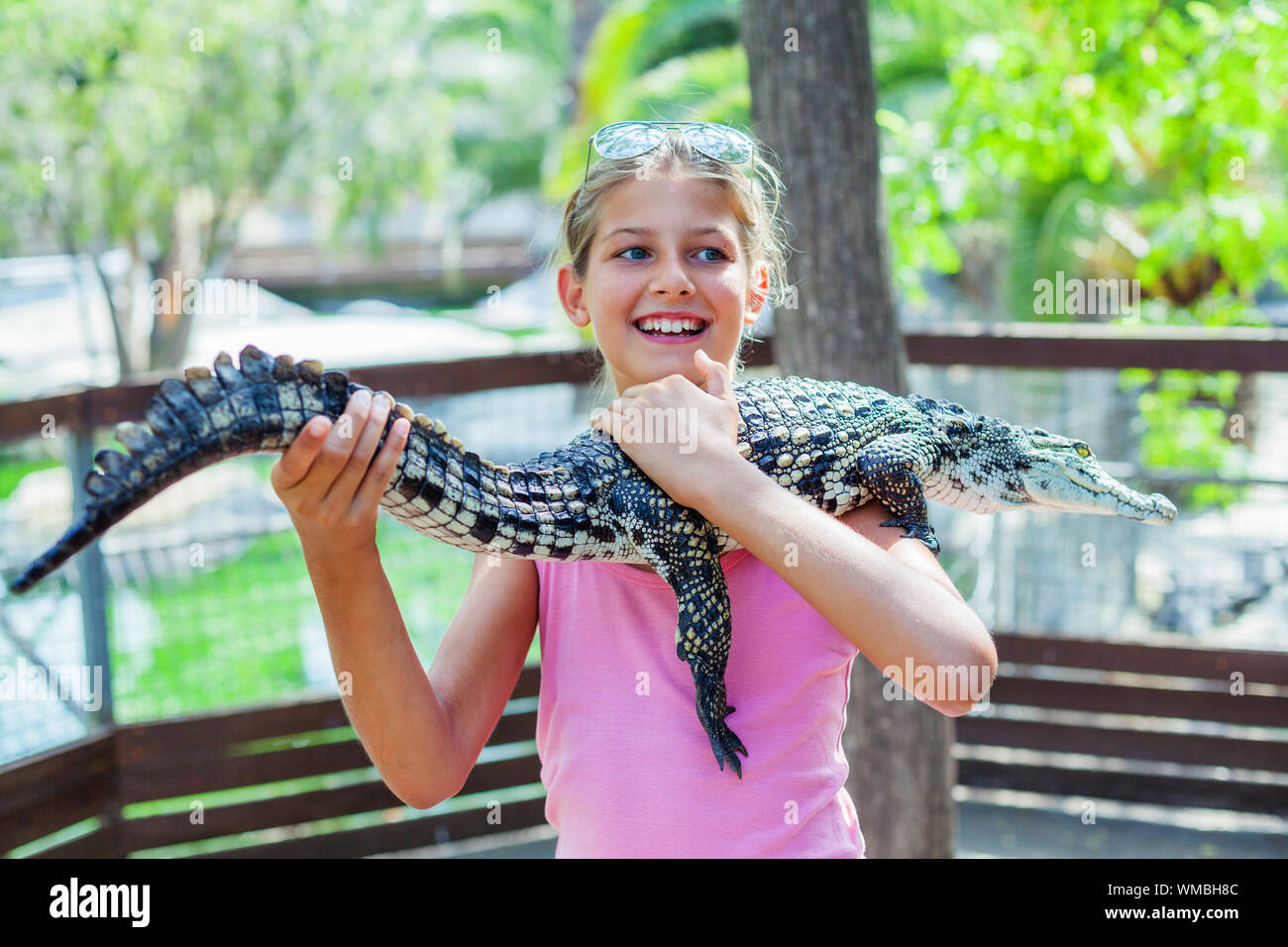Cute girl hold real crocodile on crocodile farm Stock Photo - Alamy