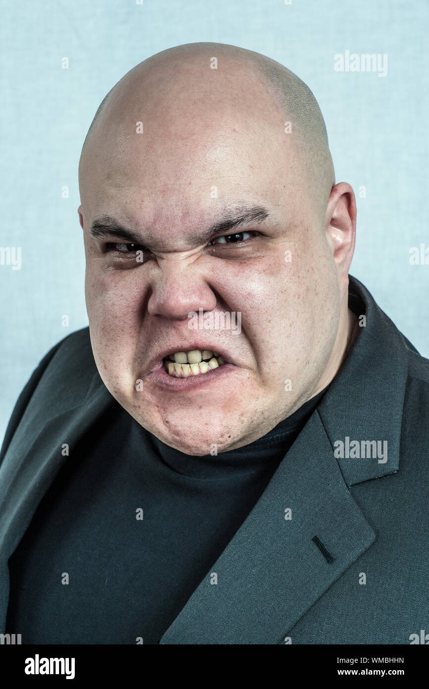 Photo of an angry bald man grimacing at the camera. Filtered to be more creepy Stock Photo - Alamy