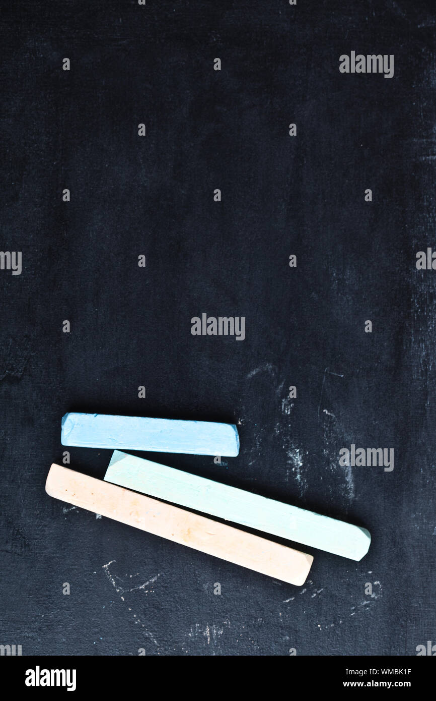 three pieces of chalk over a blackboard Stock Photo - Alamy