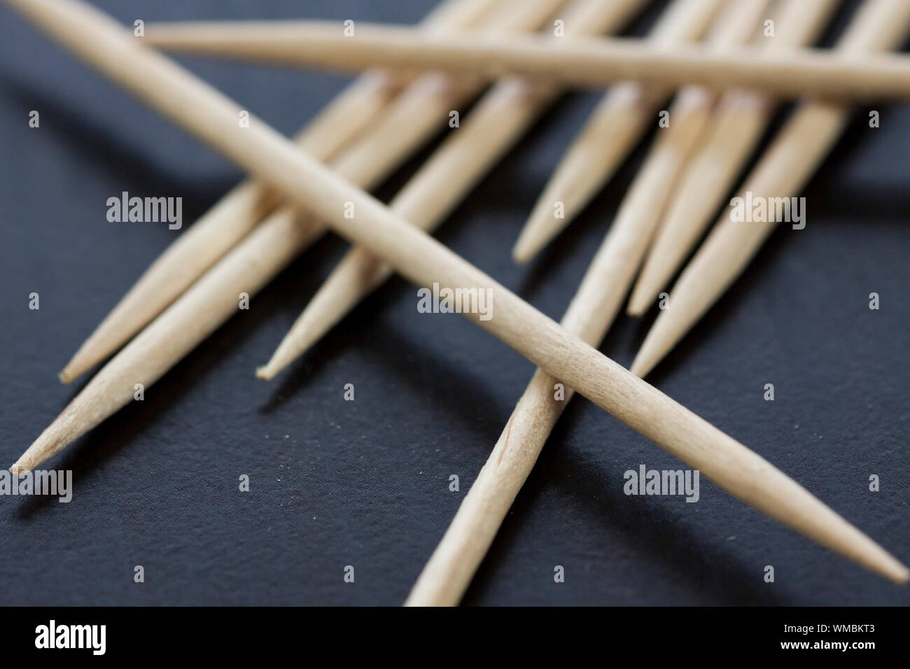 Pile of wooden toothpicks scattered randomly on a grey background for ...