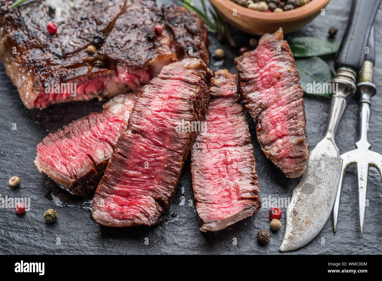 Medium rare Ribeye steak with herbs on graphite board Stock Photo - Alamy