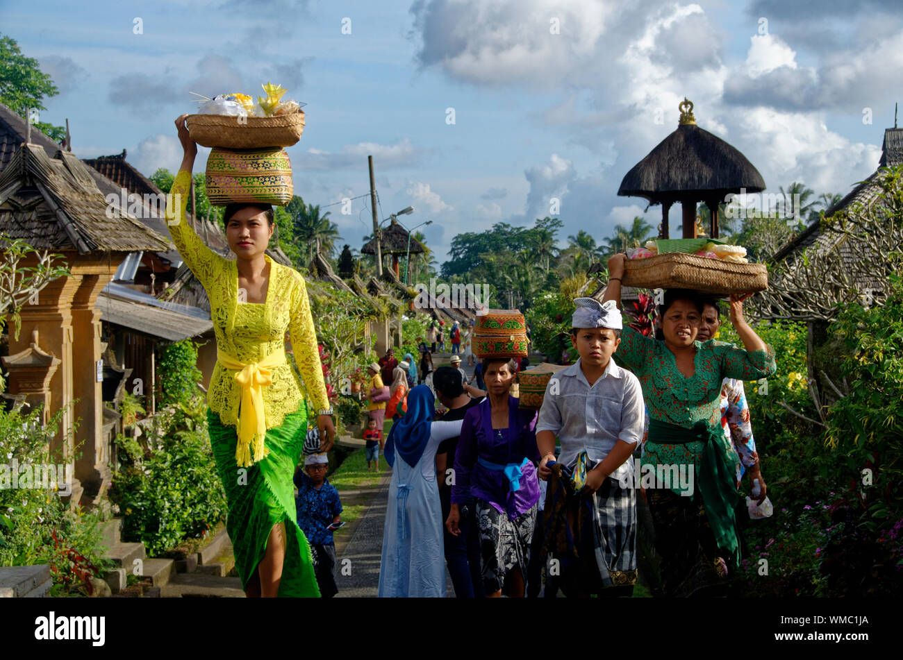 Young Balinese women carrying baskets on their heads in traditional ...