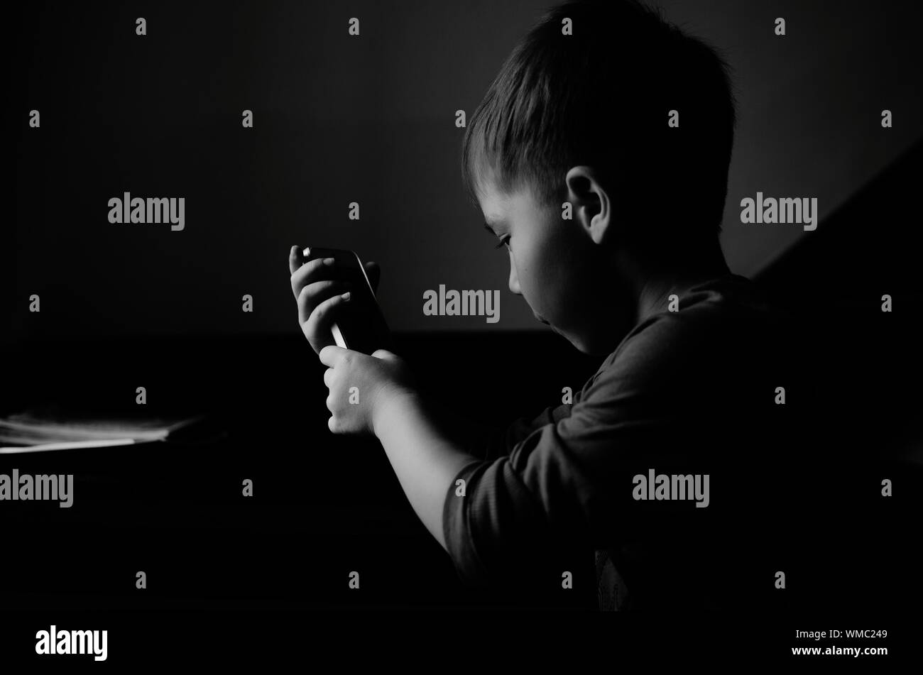 Side View Of Child Playing With Smart Phone Stock Photo - Alamy