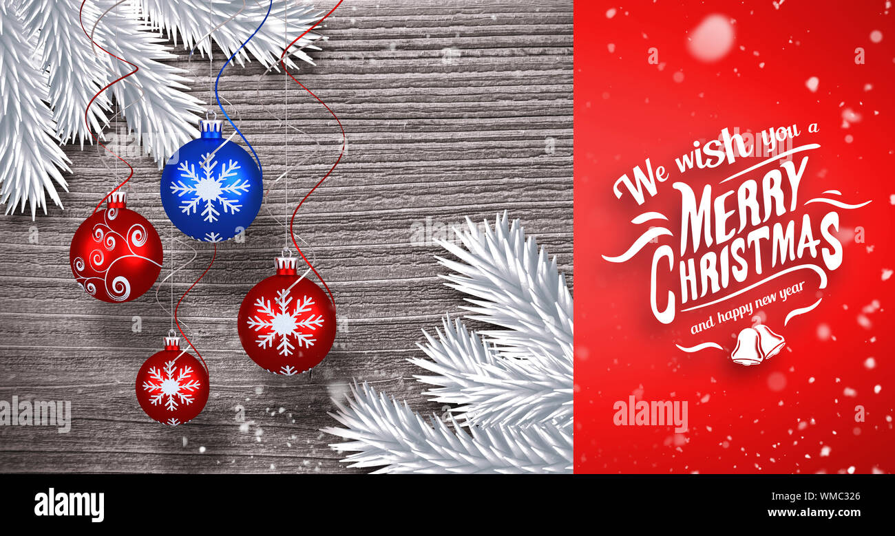 Snow falling against christmas baubles hanging over wood Stock Photo ...