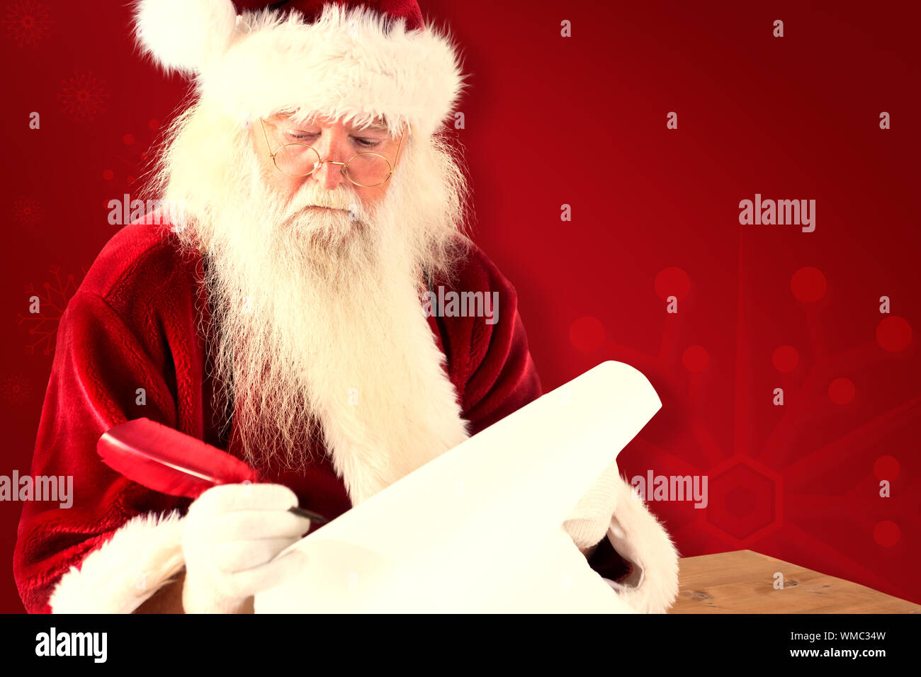 Santa writes something with a feather against red background Stock ...