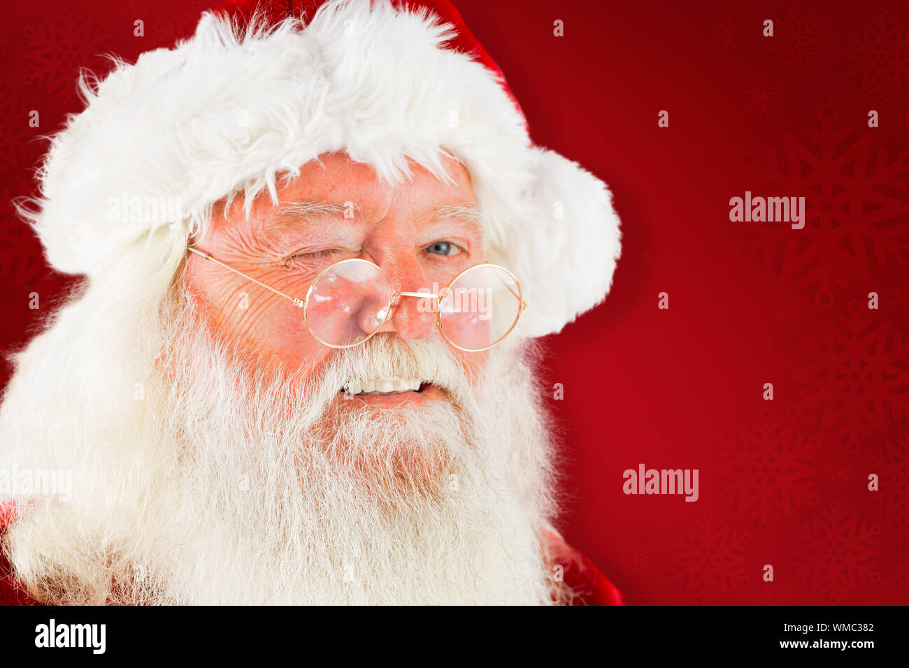 Santa claus winking against red background Stock Photo - Alamy