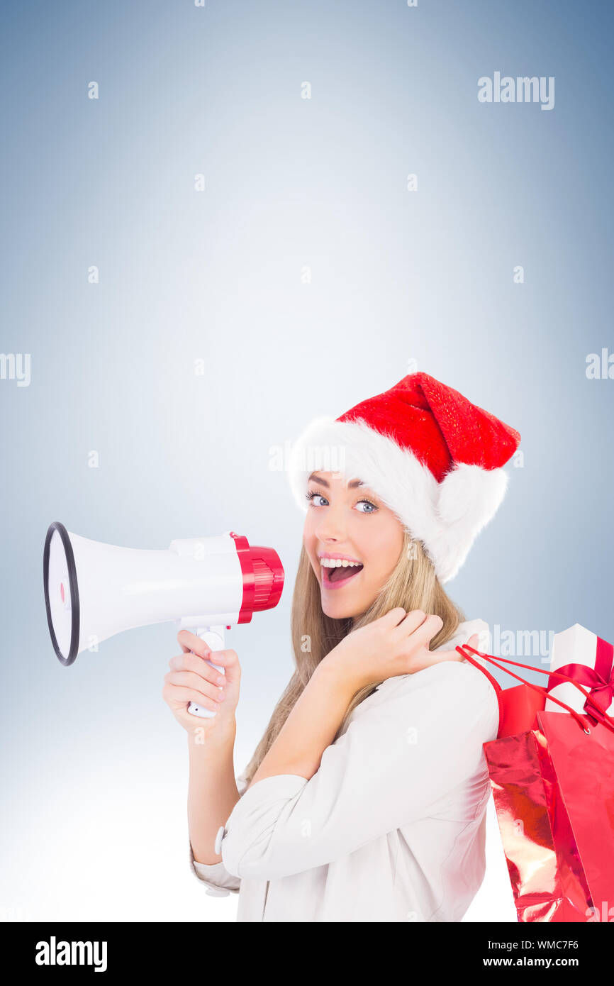 Festive blonde holding megaphone and bags on vignette background Stock ...