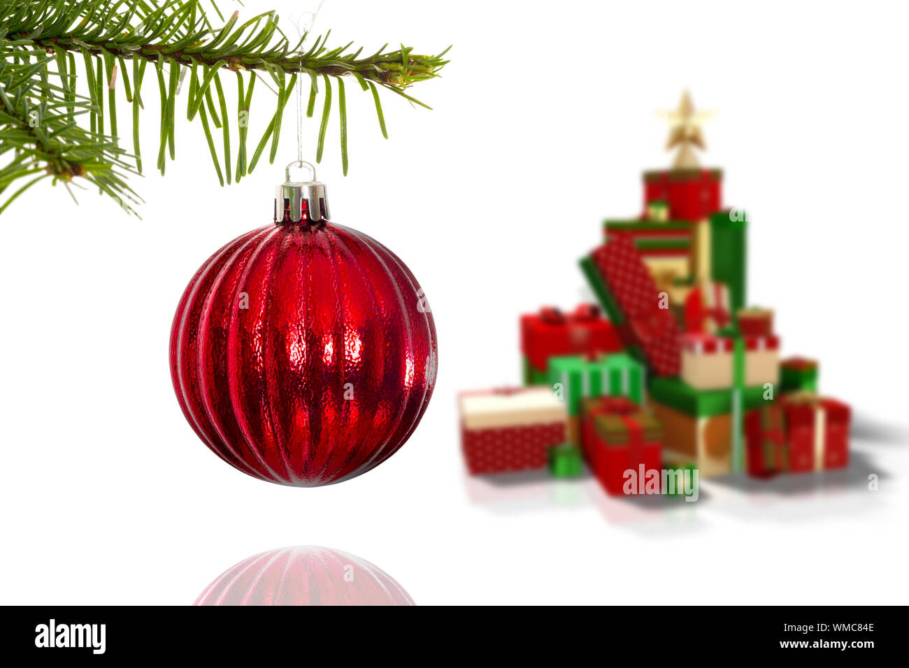 Red christmas decoration hanging from branch against green red and gold ...