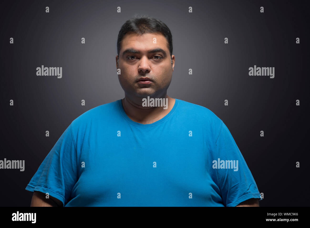 Portrait of fat man against a black background Stock Photo - Alamy