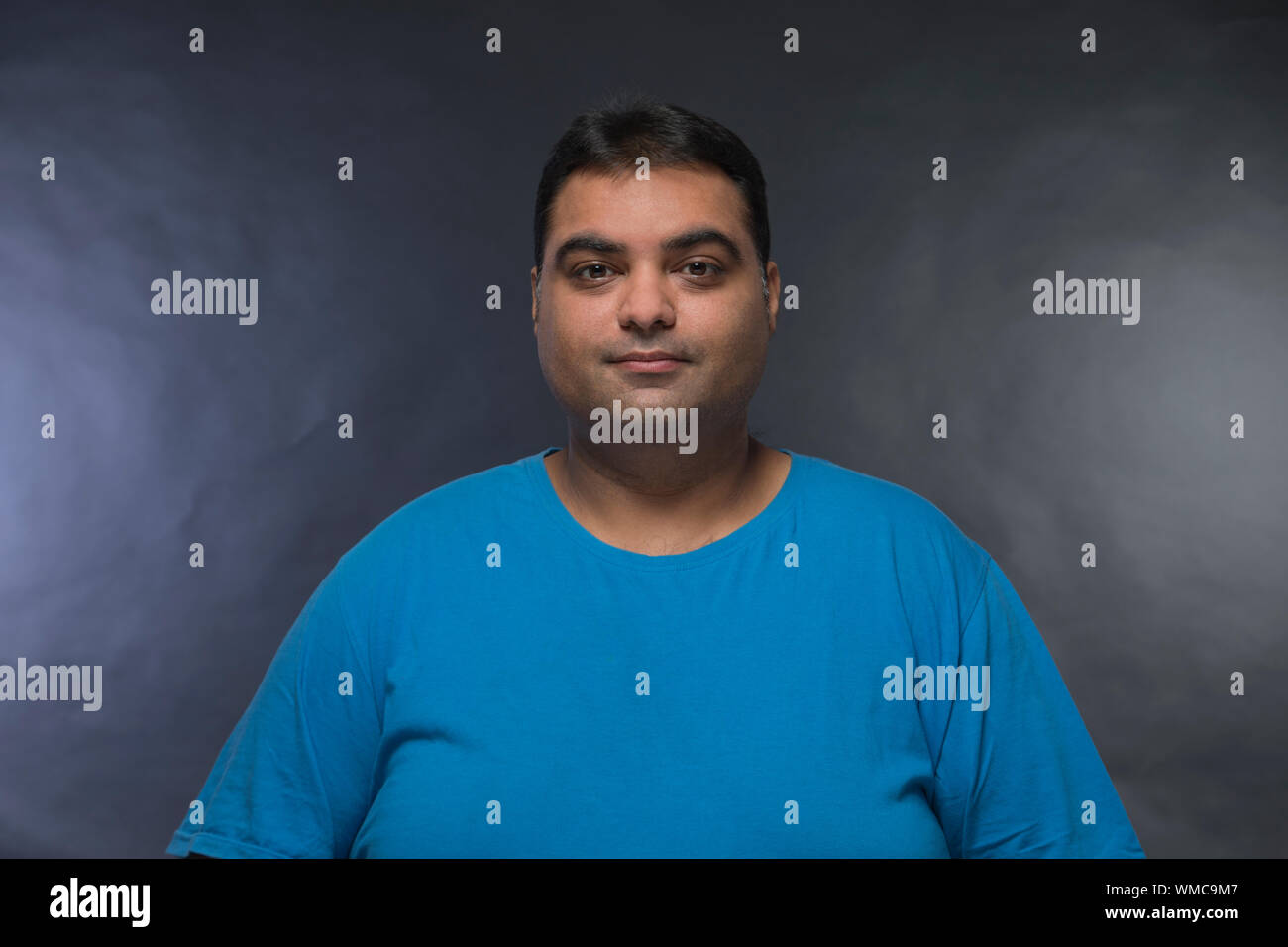Portrait of smiling fat man against a black background Stock Photo - Alamy