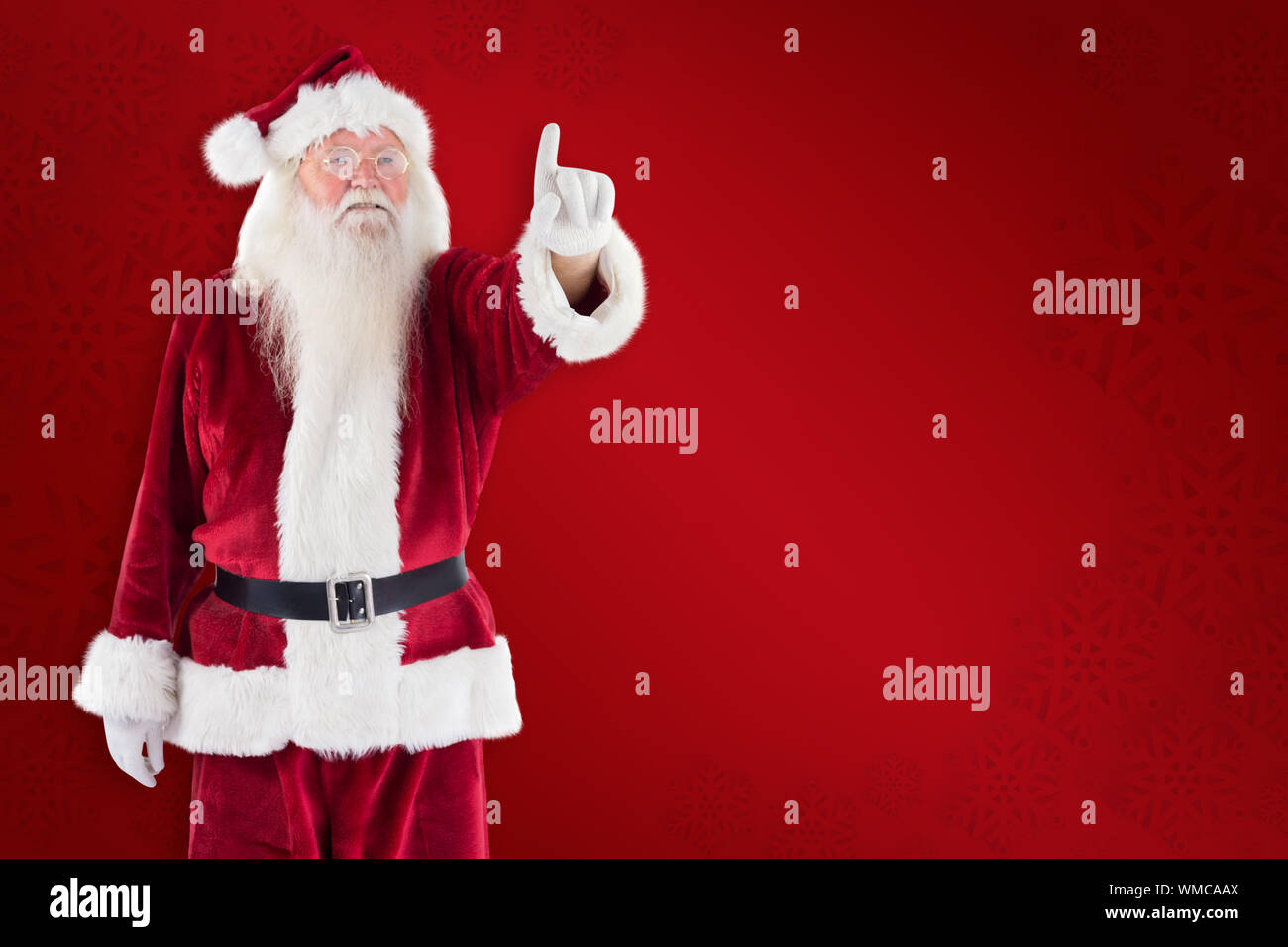 Santa Claus points at something against red background Stock Photo - Alamy