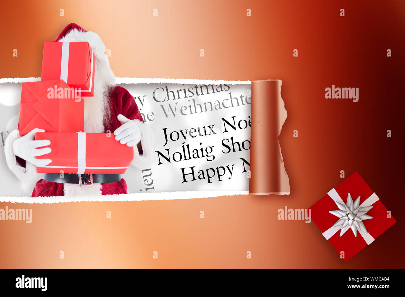 Santa covers his face with presents through tear in shiny paper Stock ...