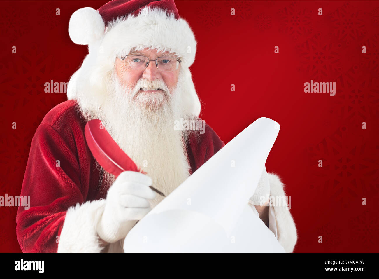 Santa claus writing on scroll against red background Stock Photo - Alamy