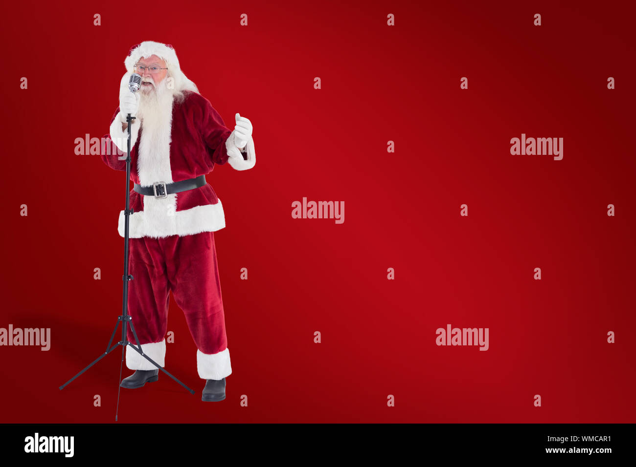 Santa sings like a Superstar against red background Stock Photo - Alamy