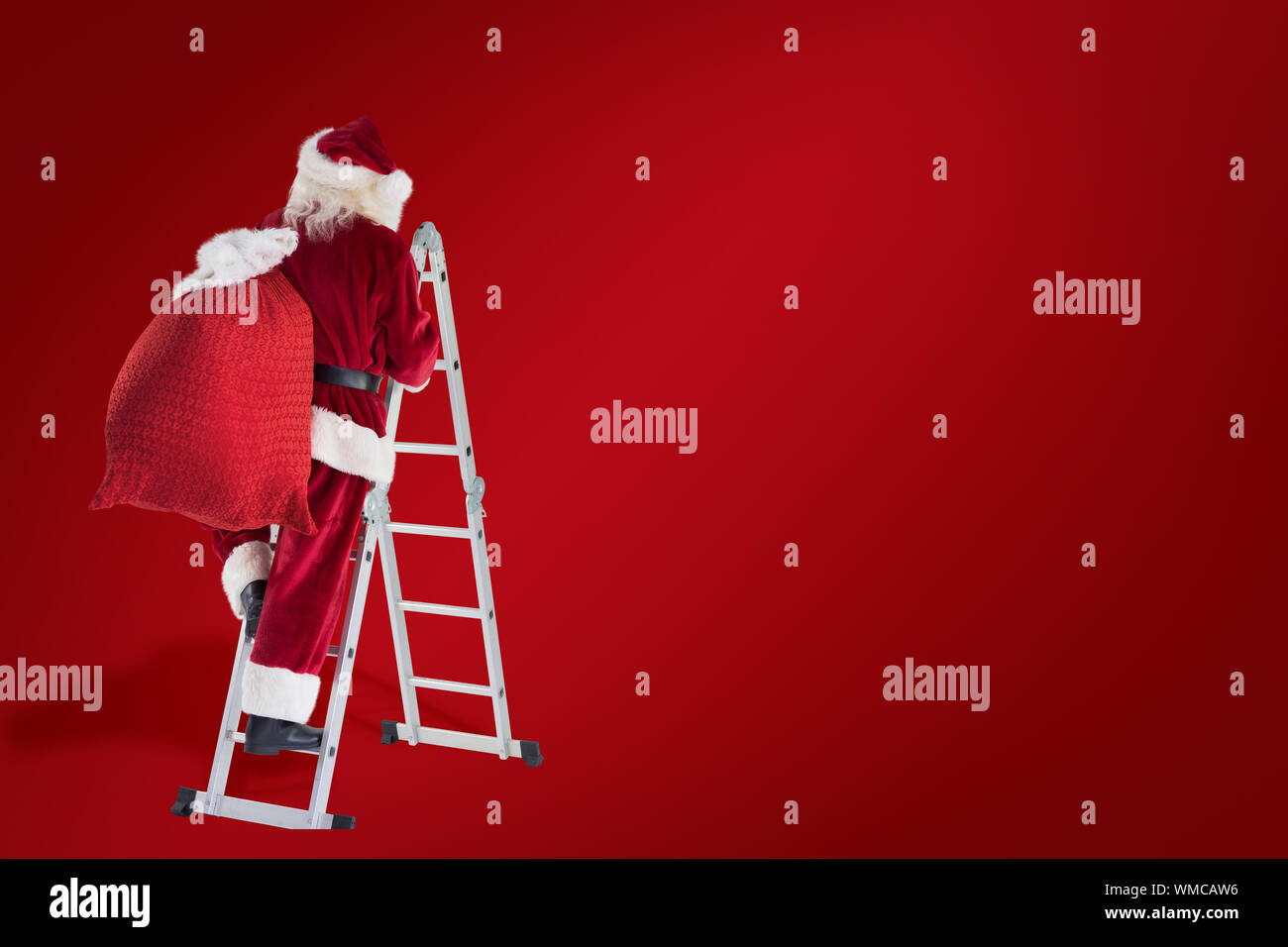 Santa steps up a ladder against red background Stock Photo - Alamy