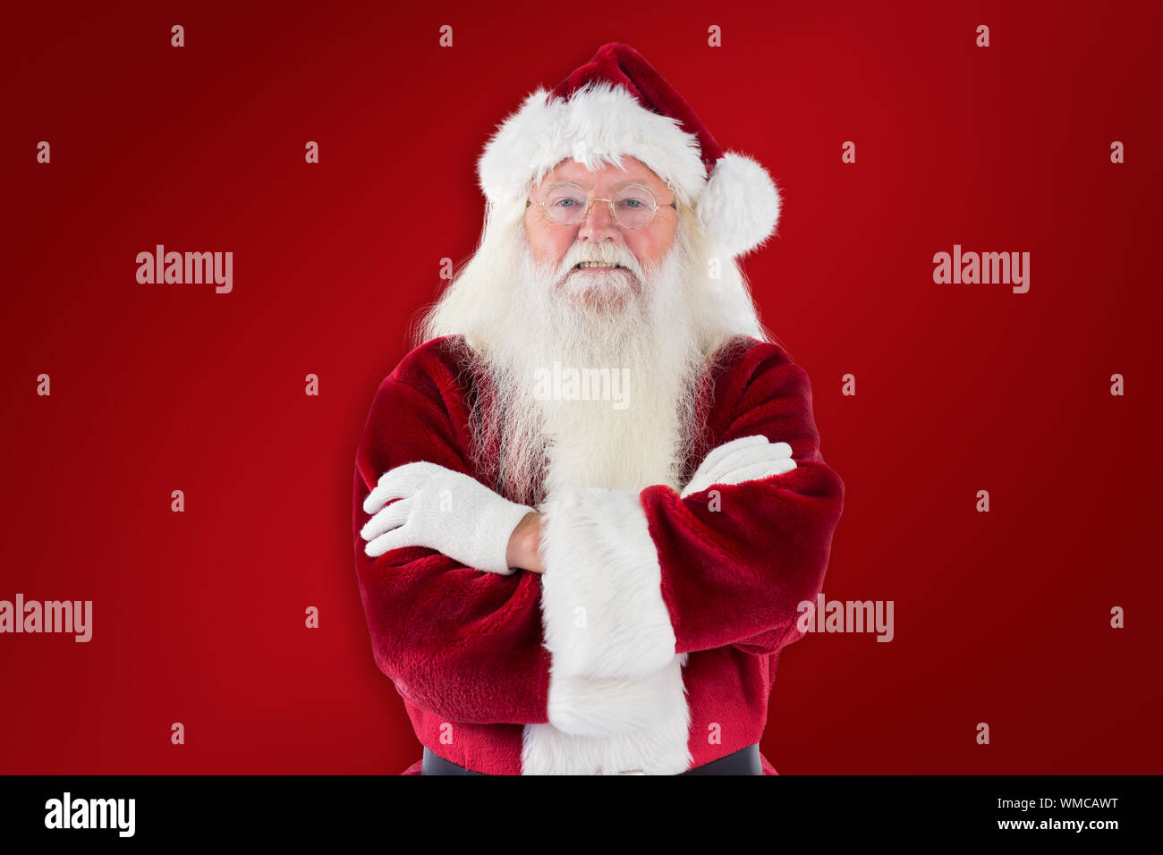 Santa smiles with folded arms against red background Stock Photo - Alamy