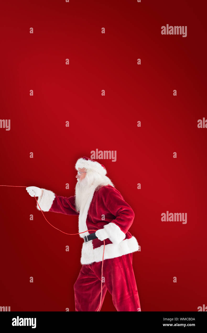 Santa pulls something with a rope against red background Stock Photo ...