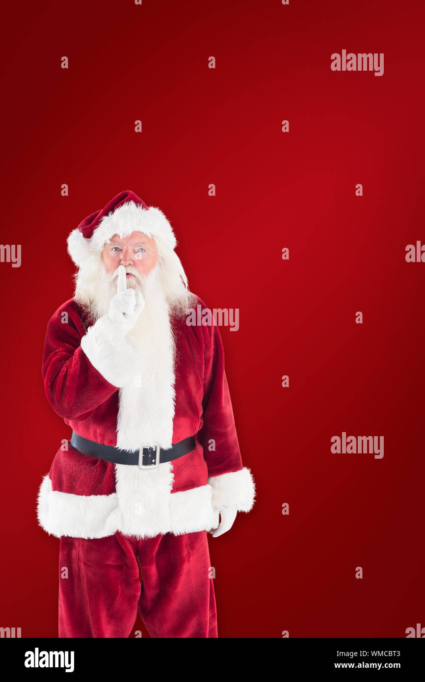 Santa asking for quiet to camera against red background Stock Photo - Alamy
