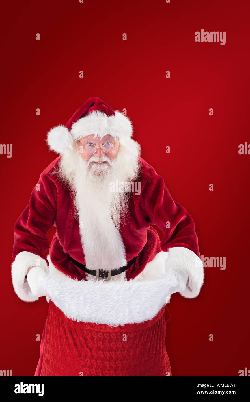 Santa open his red bag against red background Stock Photo - Alamy